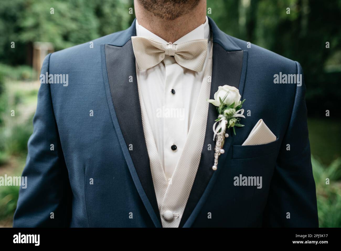 A handsome, formally dressed man stands confidently wearing a black ...