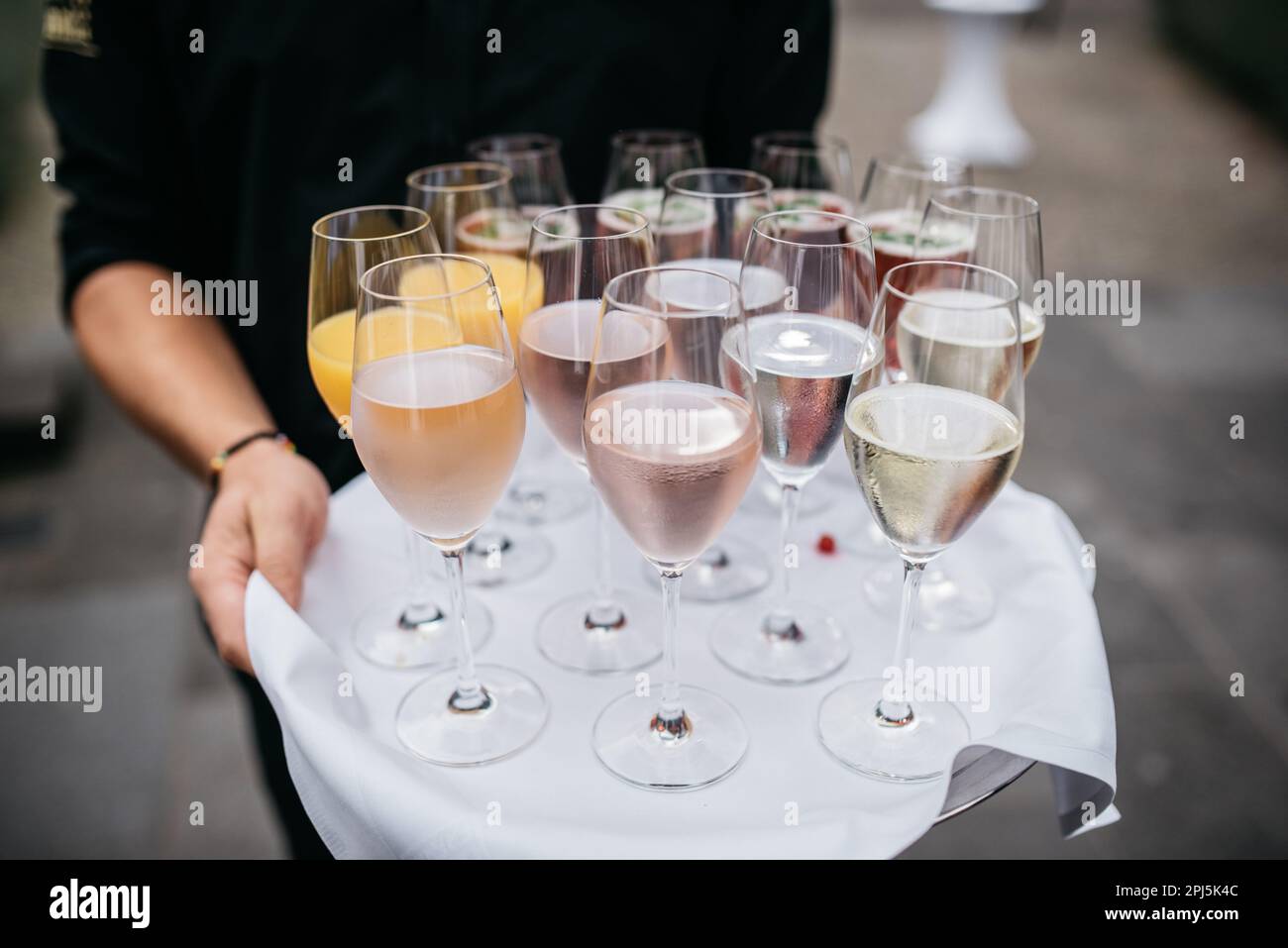 A waiter carrying a tray full of an assortment of drinks Stock Photo ...