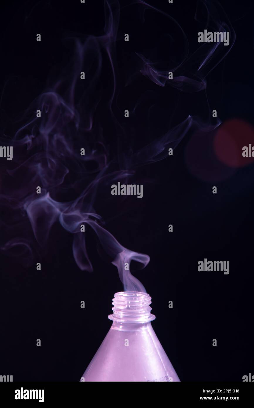 Moving smoke coming out of a plastic bottle. Isolated on black ...