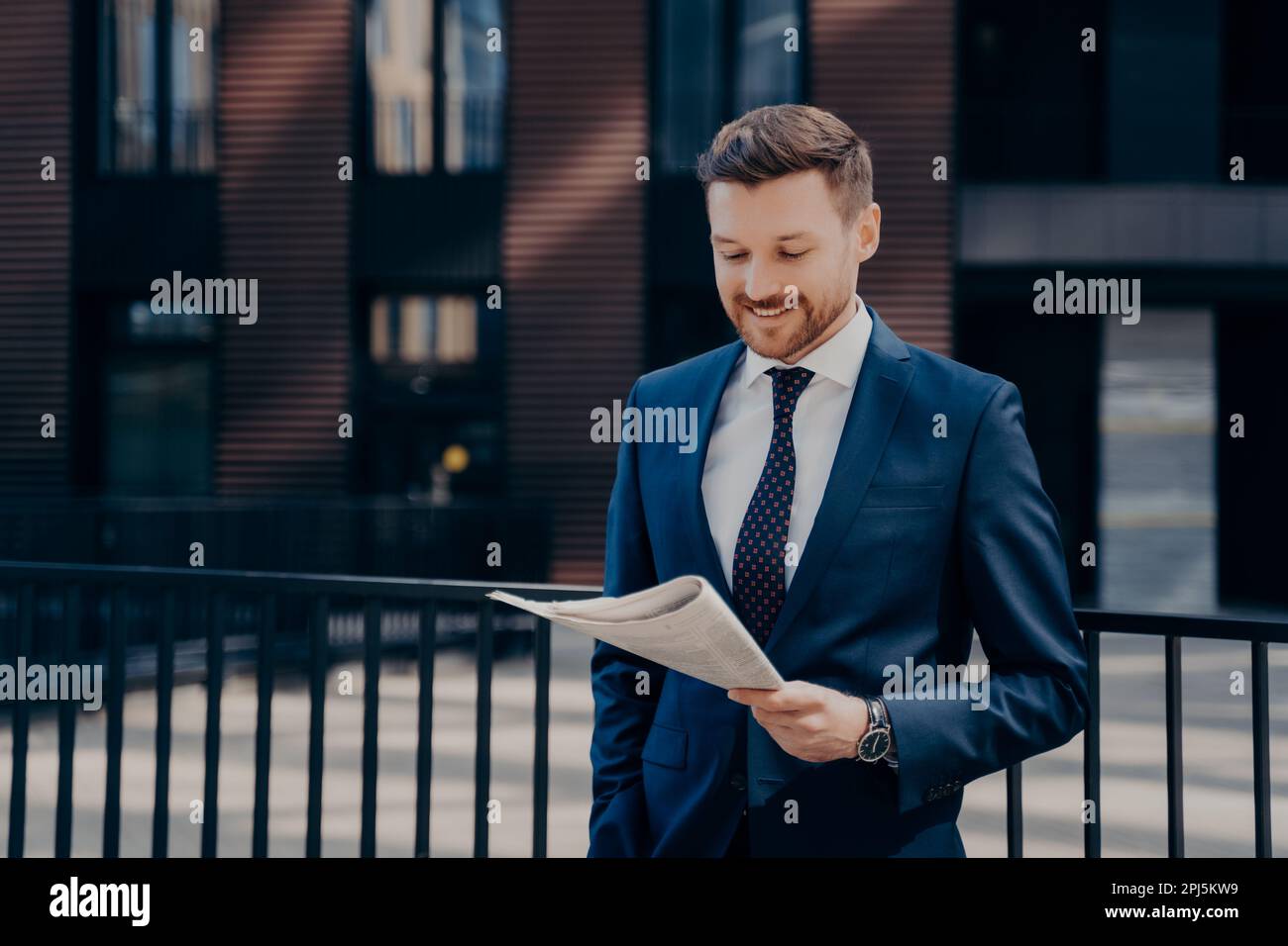 Good news. Young rich progressive firm owner reading newspaper with ...