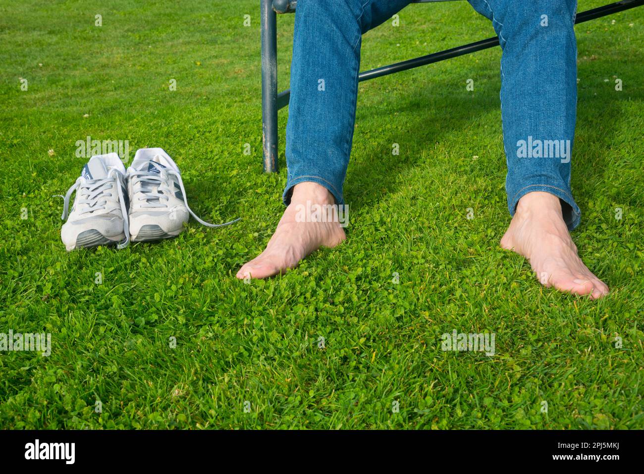 Man's feet resting on the grass Stock Photo - Alamy