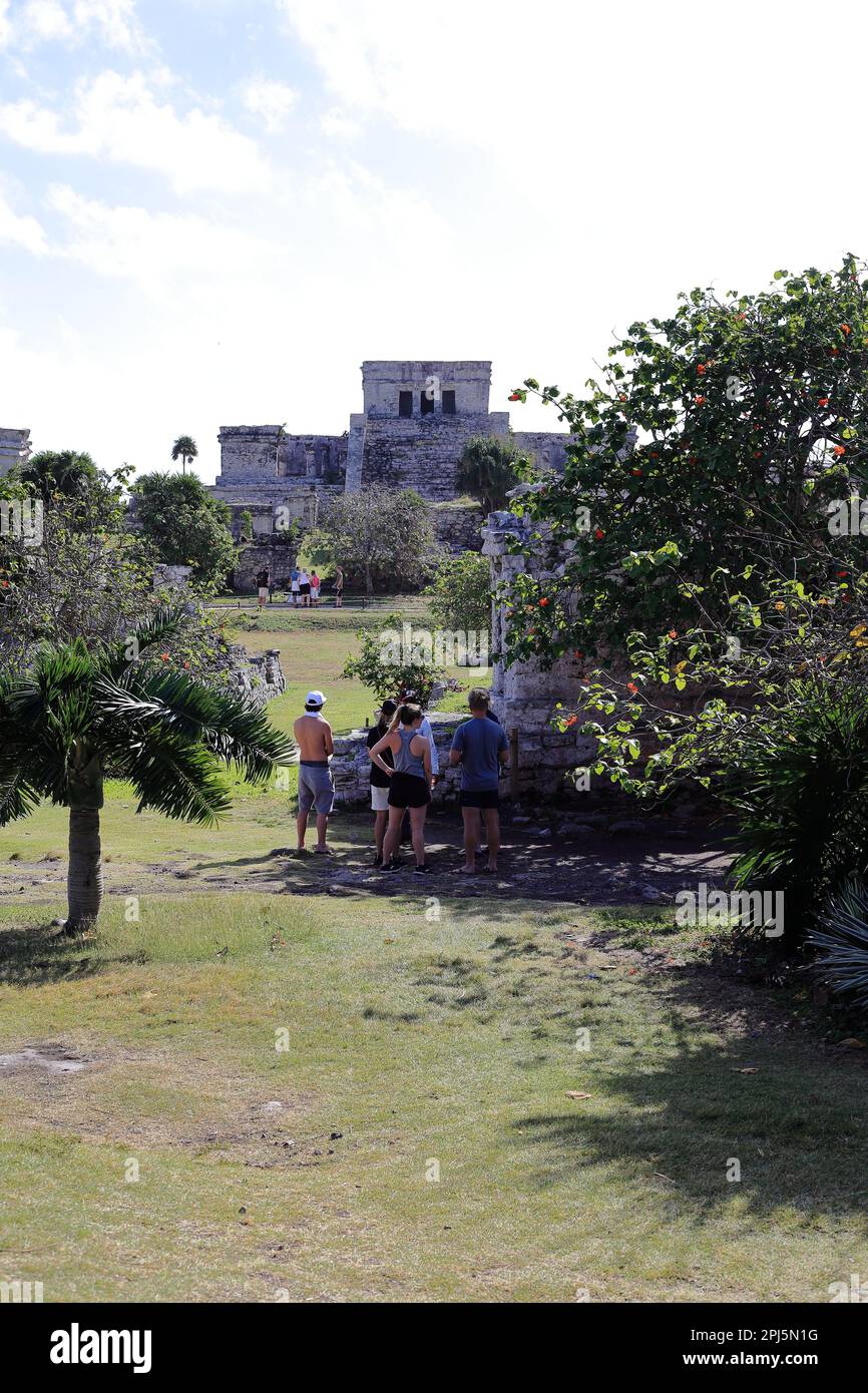 Guide & tourists in the Tulum Archaeological Zone with El Castillo in ...