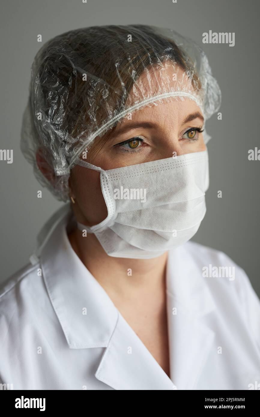 Doctor with face covered with mask. Portrait of young woman wearing the ...