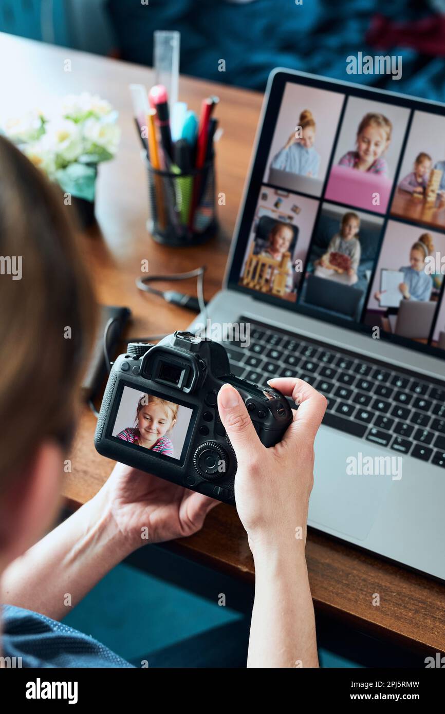 Female photographer working on photos on laptop and camera. Woman ...