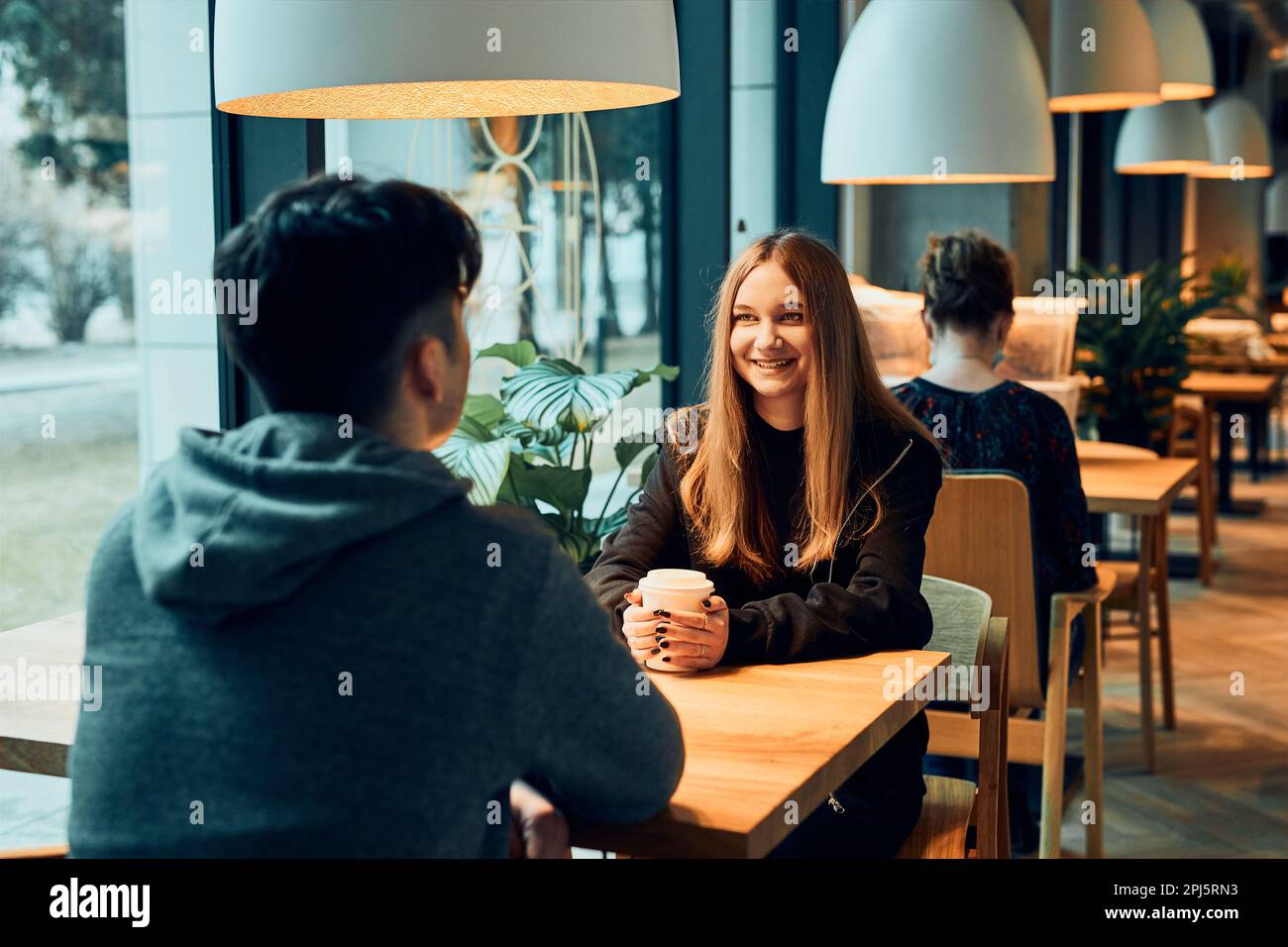 Friends having a chat, talking together, drinking coffee, sitting in a ...