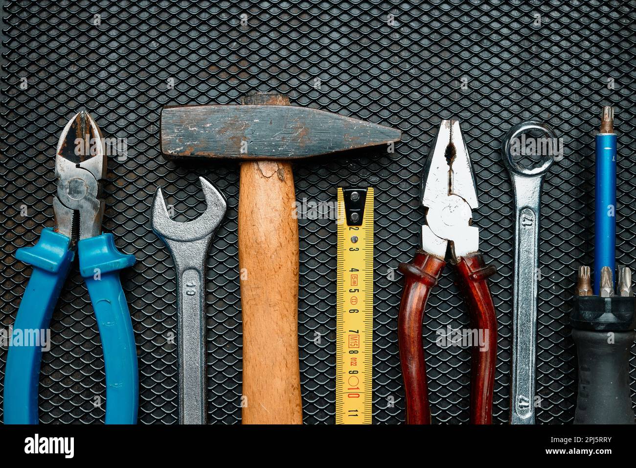 Hardware tools wrench screwdriver tape hammer on steel surface ...