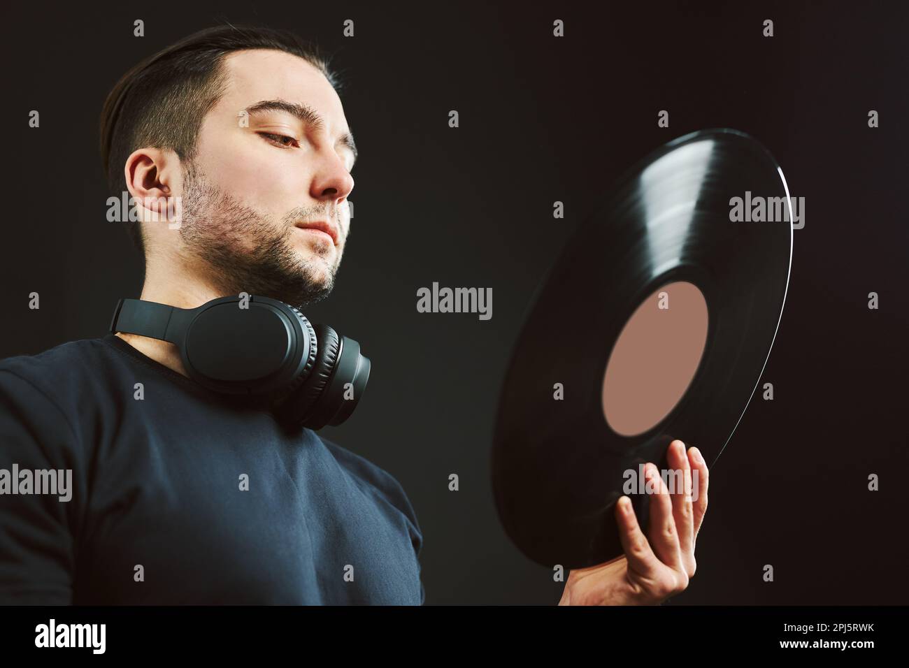 Man looking at vinyl record. Vintage music style. Male with headphones ...