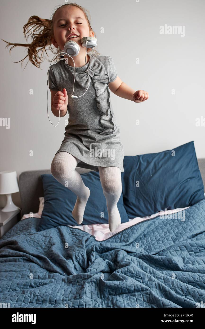 Little girl singing holding headphones cord imitating herself a real ...
