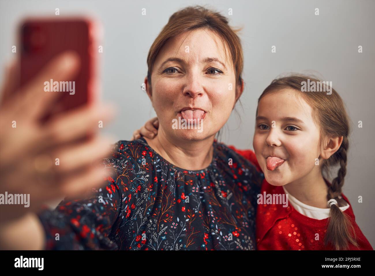 Mother with her little daughter making video call using mobile phone ...