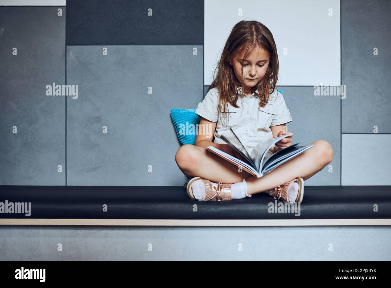 Schoolgirl reading book in school library. Primary school pupil is ...