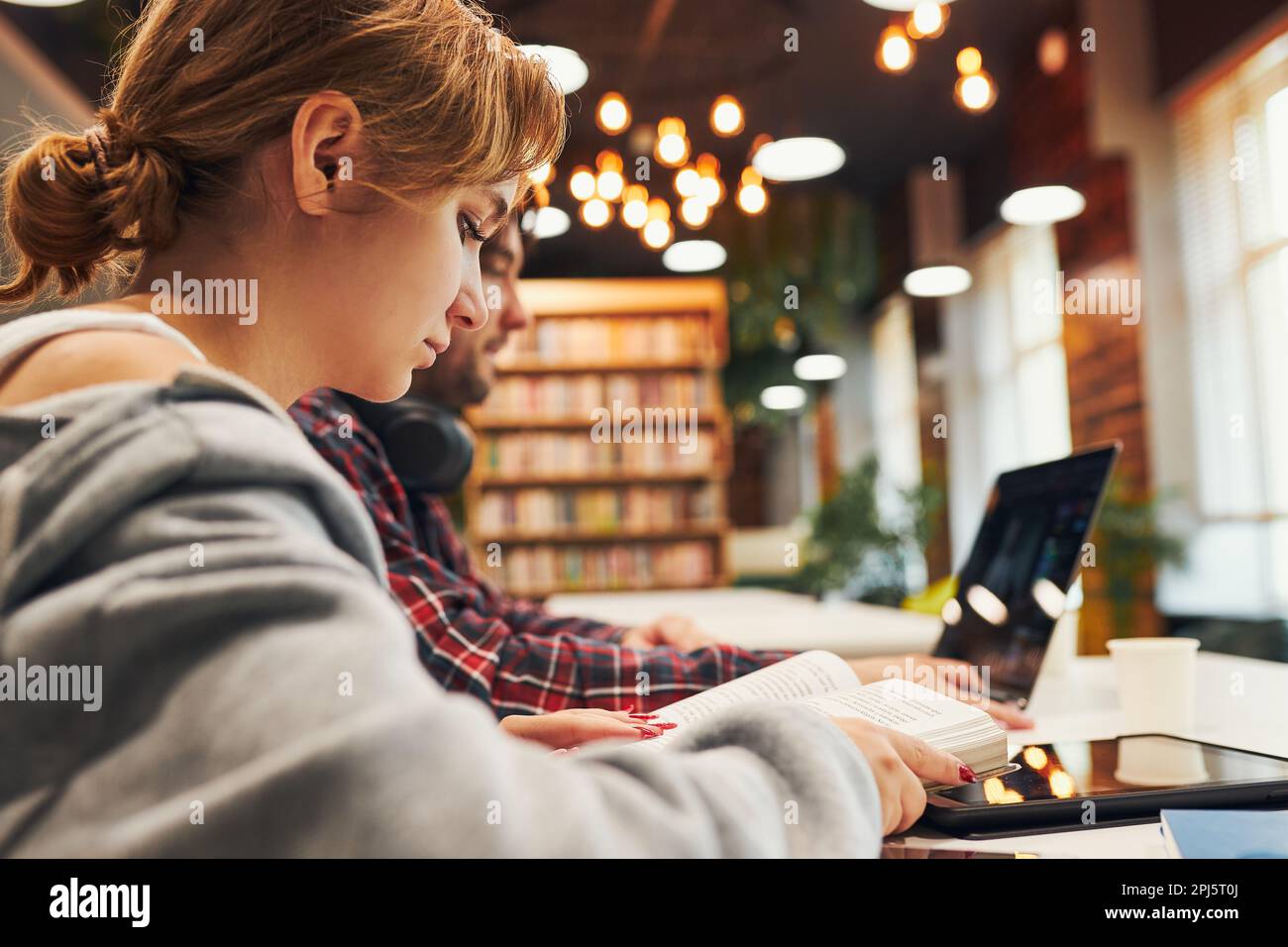 Students learning in university library. Young man preparing for test ...