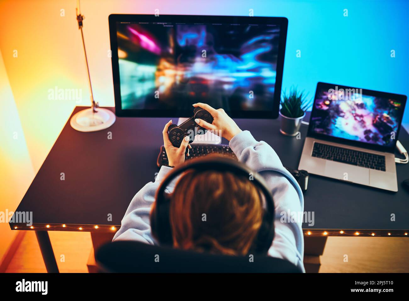 Teenager girl playing video game at home. Gamer holding gamepads ...