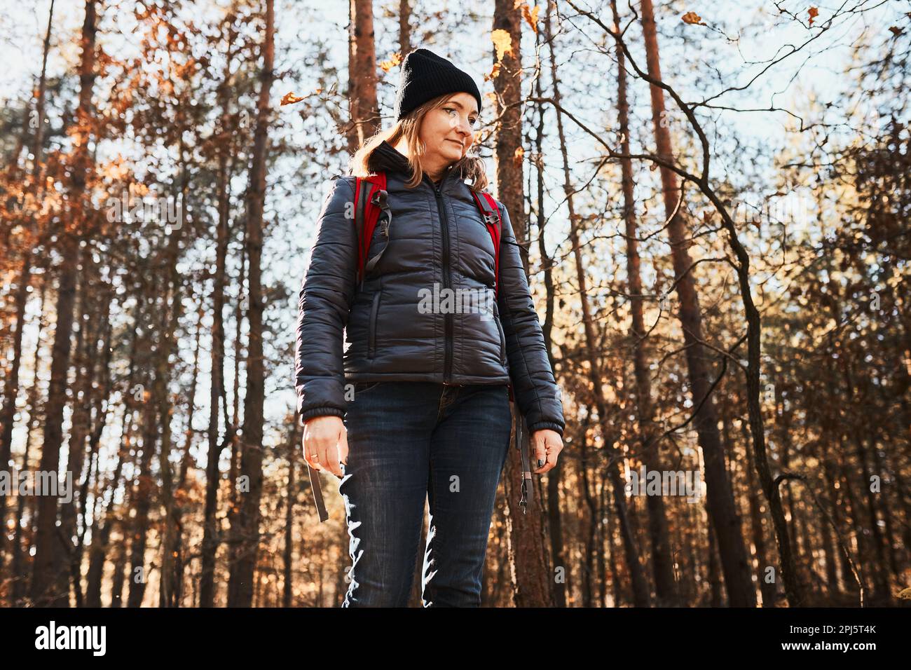Woman enjoying hike on sunny vacation day. Female with backpack walking ...