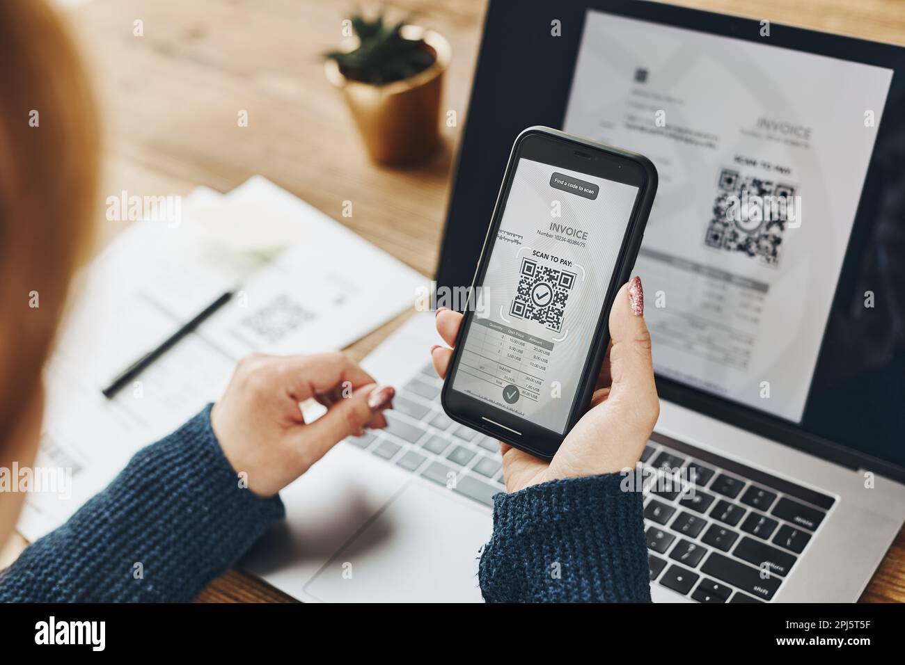 Woman scanning QR code from invoice to make payment using fast secure payment system and ...