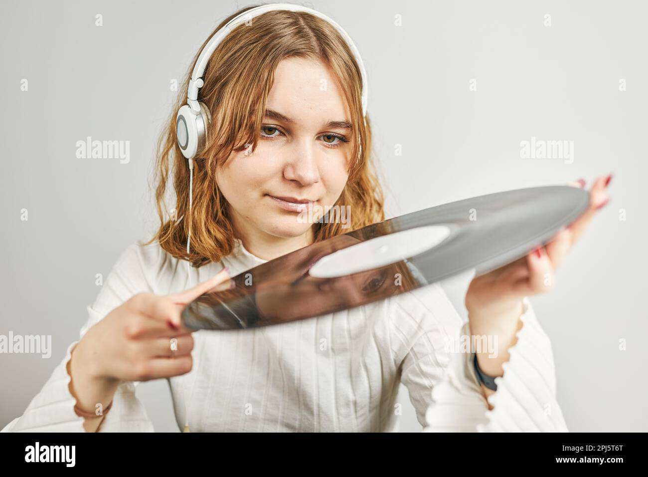 Young woman listening to music from vinyl record player. Playing music ...