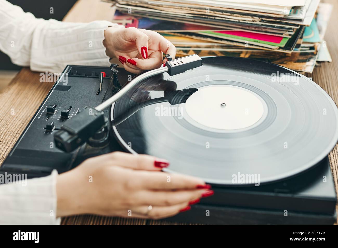Young woman listening to music from vinyl record player. Playing music ...