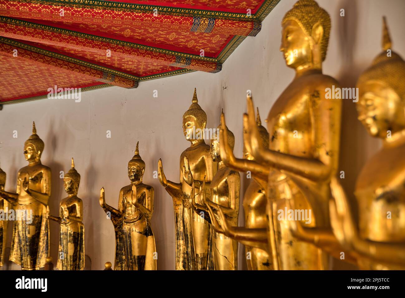 Golden Buddha figures along a corridor at Wat Pho temple in Bangok ...