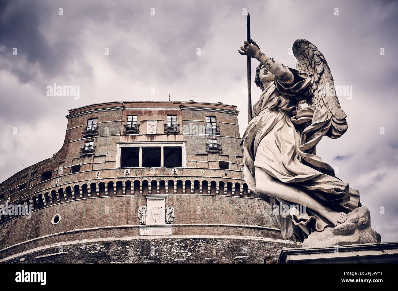 statue of an angel holding a spear with Saint Angelo castle behind it ...