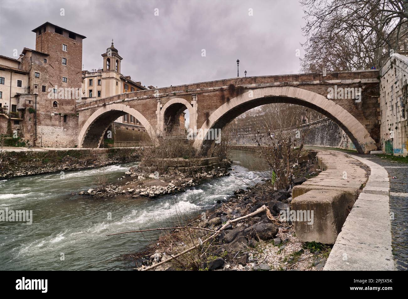 the Tiber island in Rome with ruins of old bridges and reflections on ...
