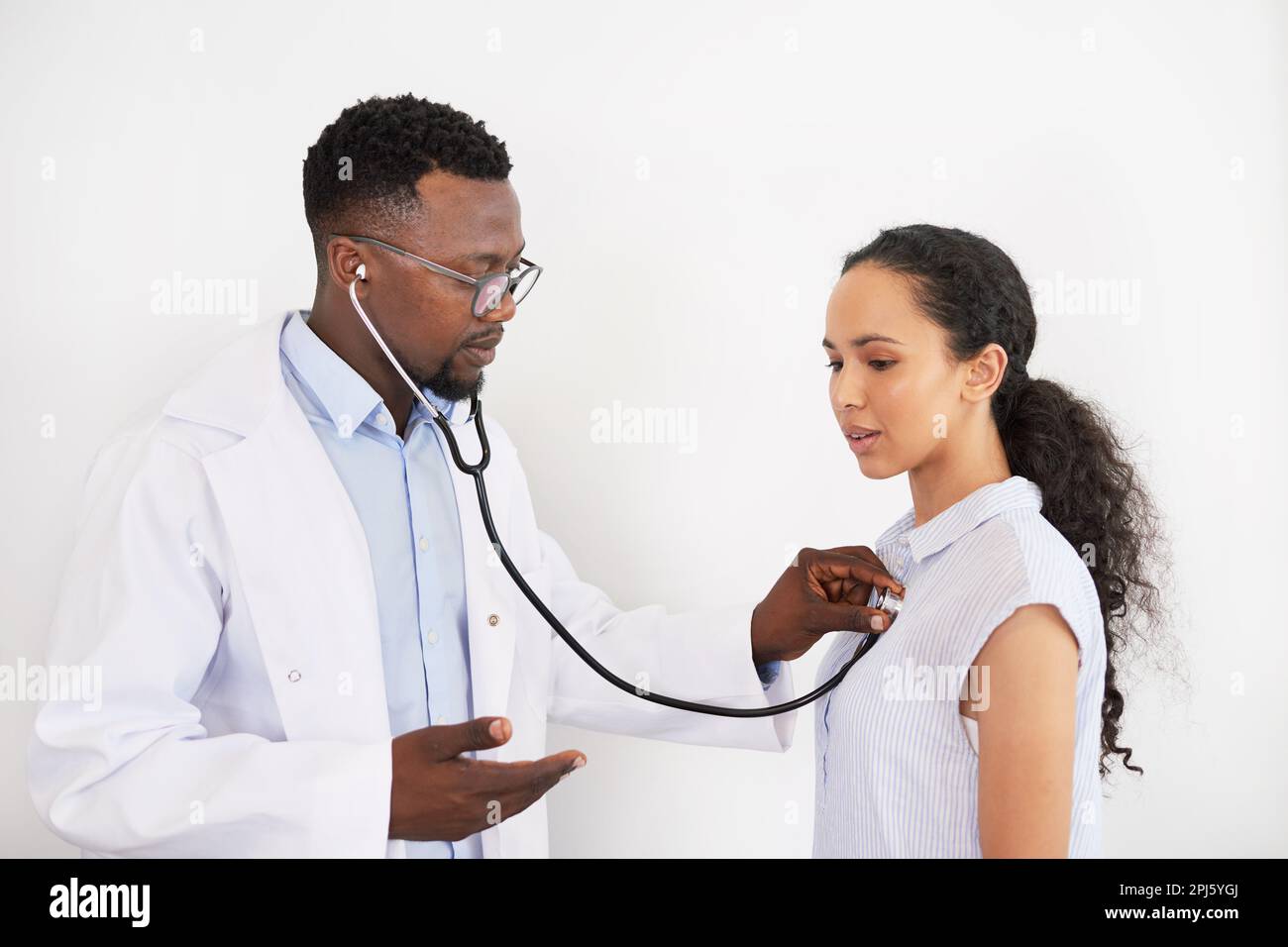 Black male doctor listens to female patient's heartbeat, tells her ...