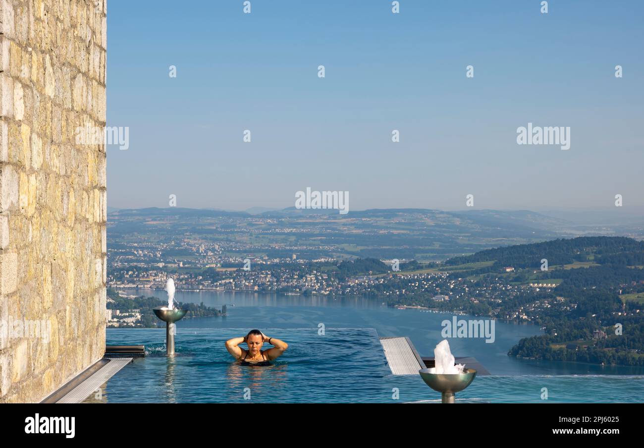 Woman in Infinity Swimming pool and Enjoy the View over Mountain and ...