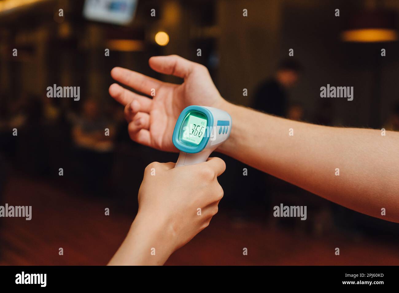 A person is having their temperature checked at public using a ...