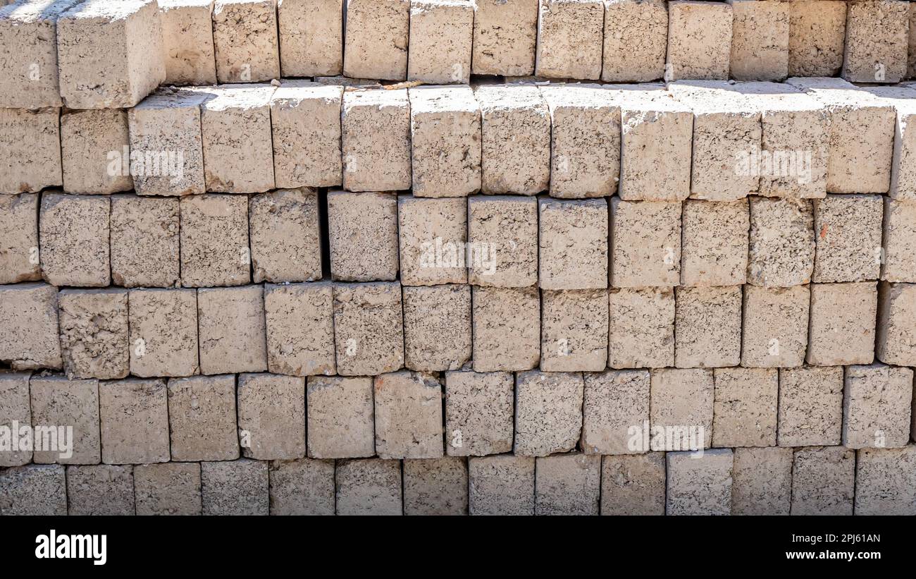 Group of stacked grayish bricks forming a wall, illuminated by sunlight ...
