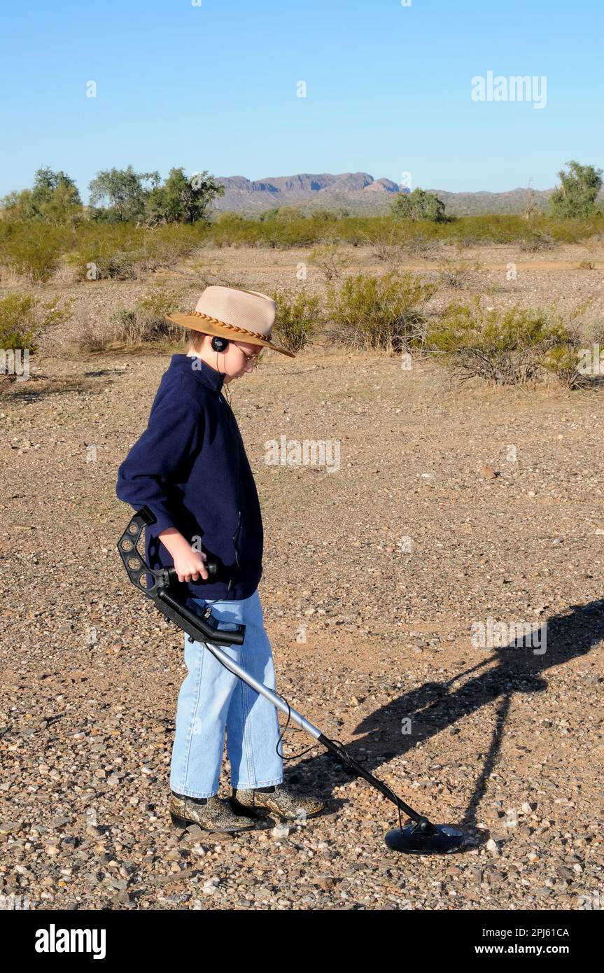 Young boy hunting for treasure with a metal detector Stock Photo - Alamy