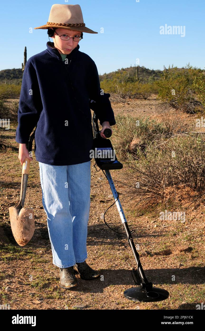 Young boy hunting for treasure with a metal detector Stock Photo - Alamy