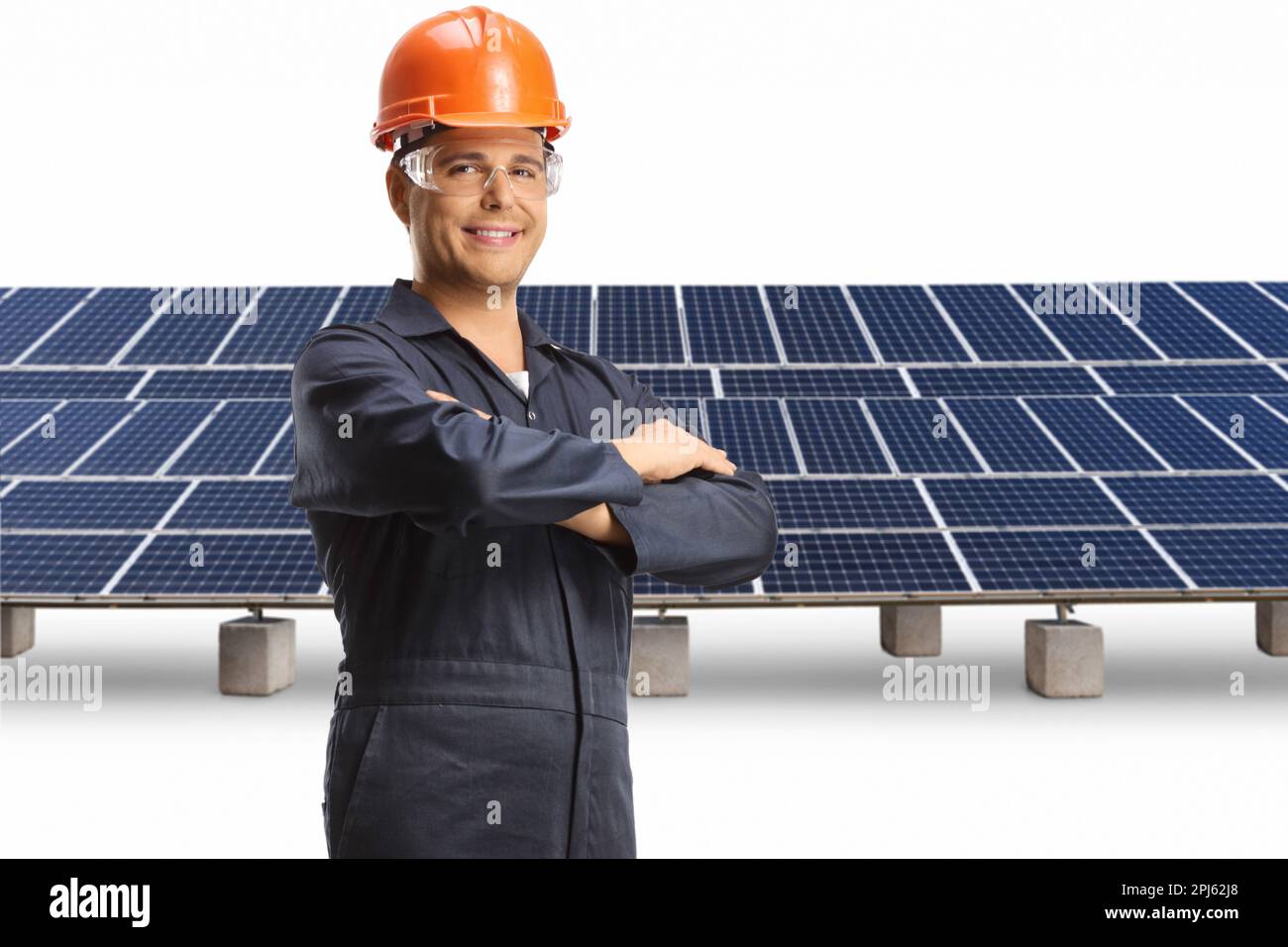 Worker wearing a helmet and uniform and posing at a solar farm isolated ...