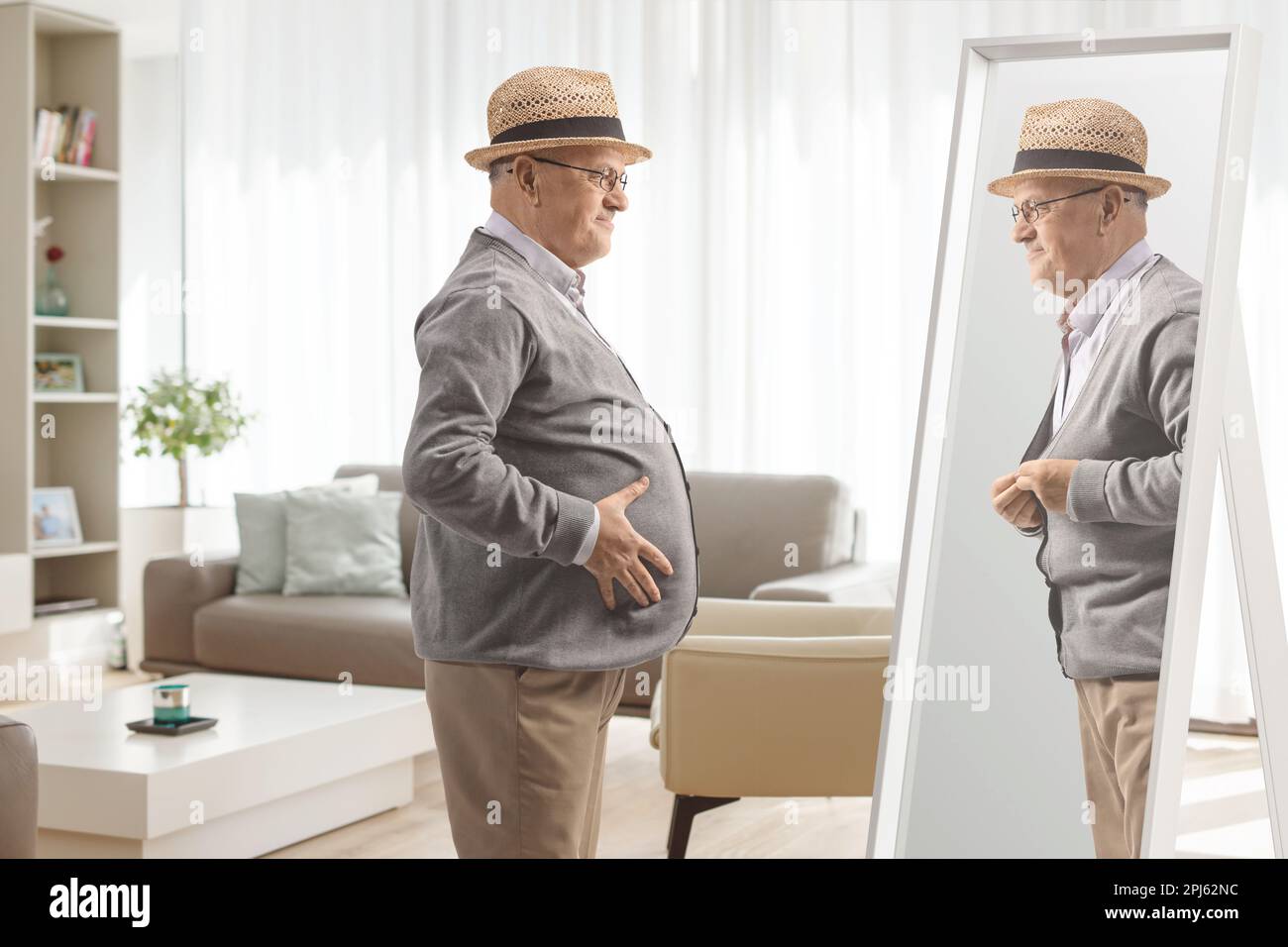 Elderly man with a big belly looking at a mirror and imagining himself ...