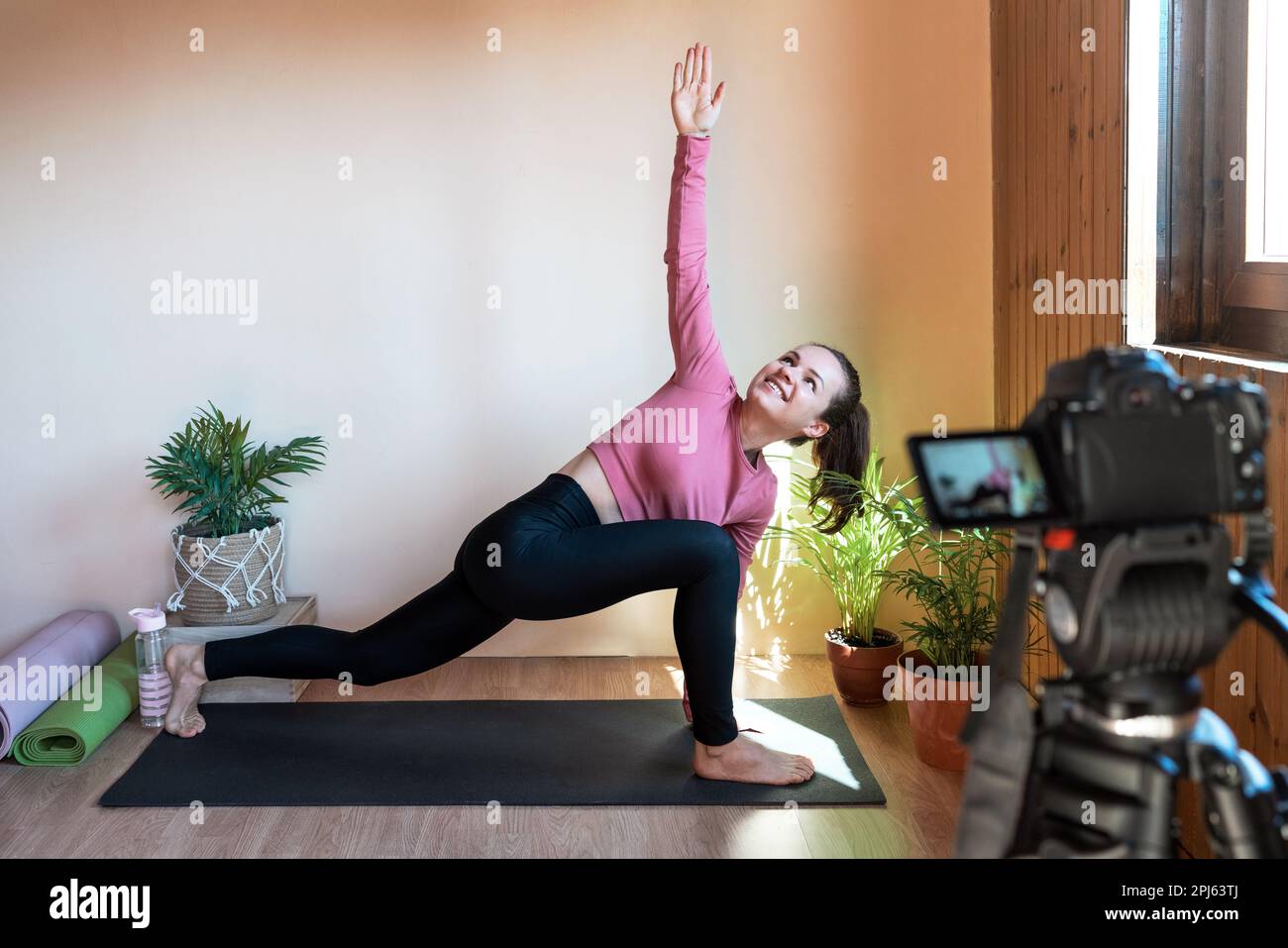 Fitness instructor doing yoga and recording healthy lifestyle vlog ...