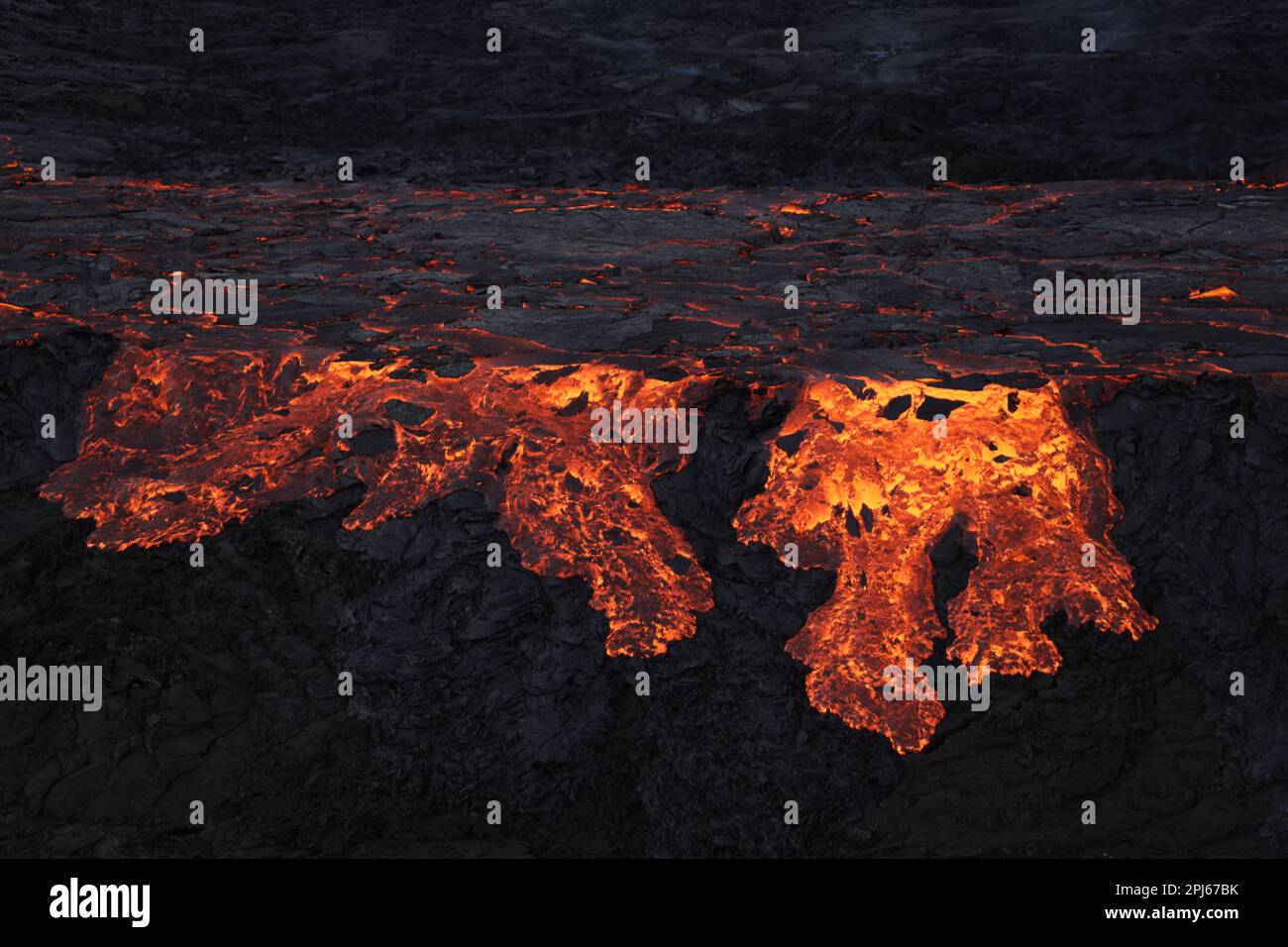 A volcanic eruption with glowing orange lava flow surrounded by a pool ...