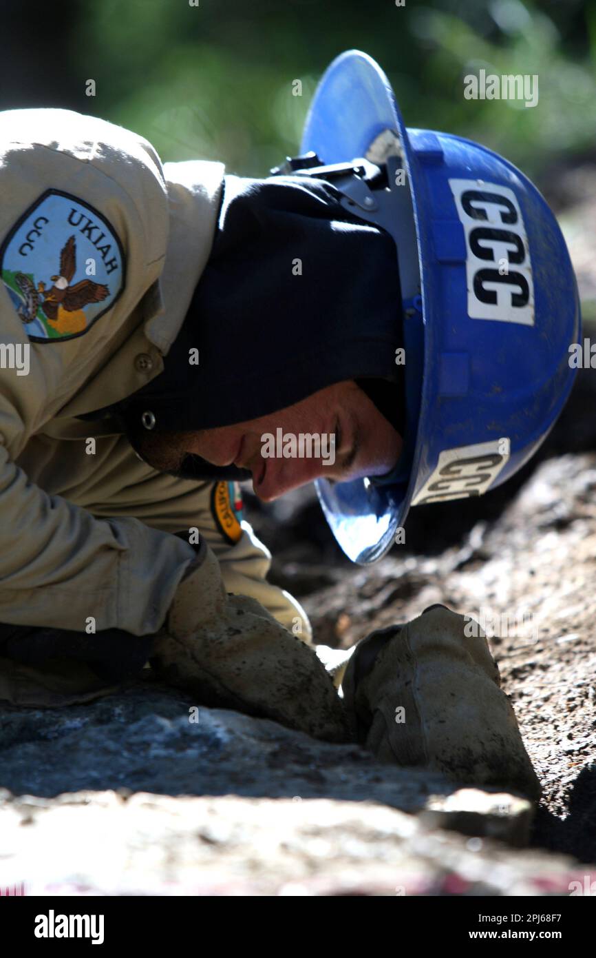 California Conservation Corps member Phil Rutherford carefully moves a ...