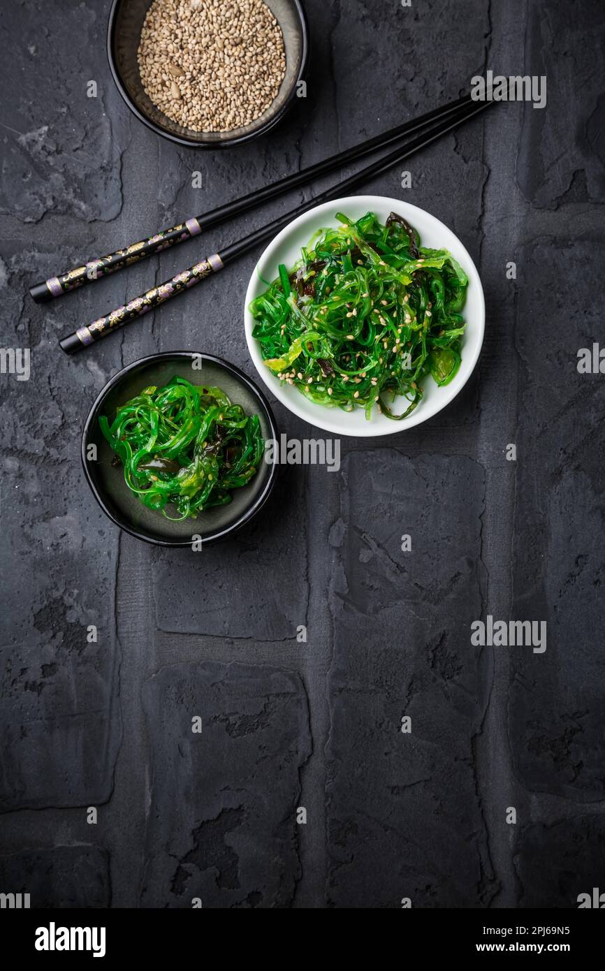 Traditional Japanese wakame salad with sesame seeds on black background ...