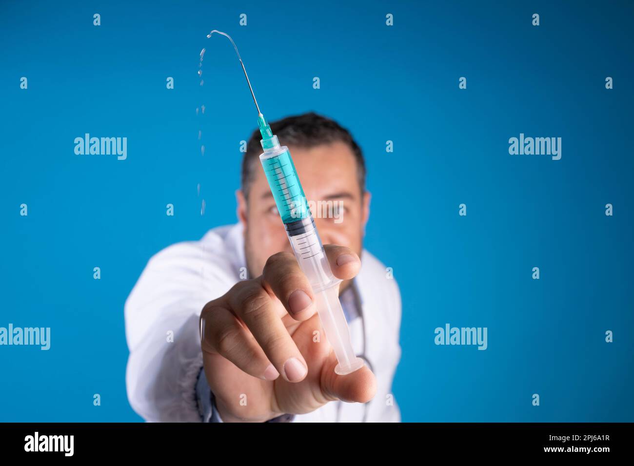 doctor holding a syringe close-up shooting medication through the ...