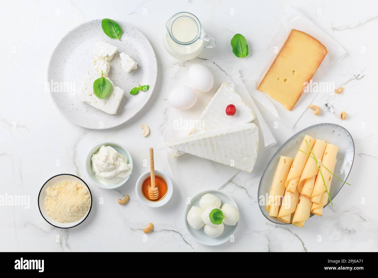Fresh dairy products on white marble background. Assortment of cheese ...