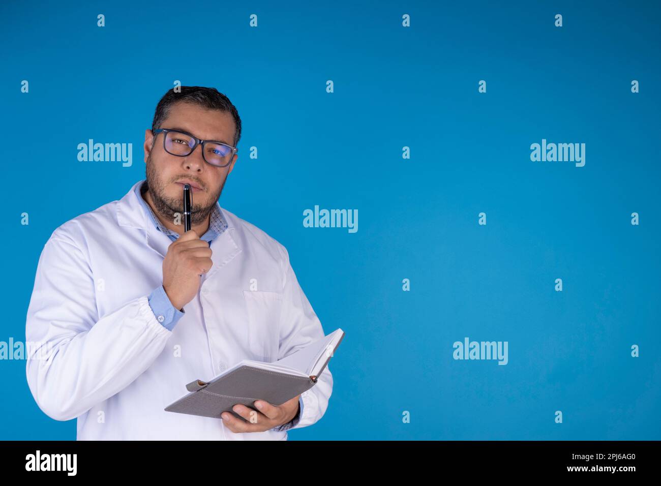 portrait of young doctor listening to his patients on a blue background ...
