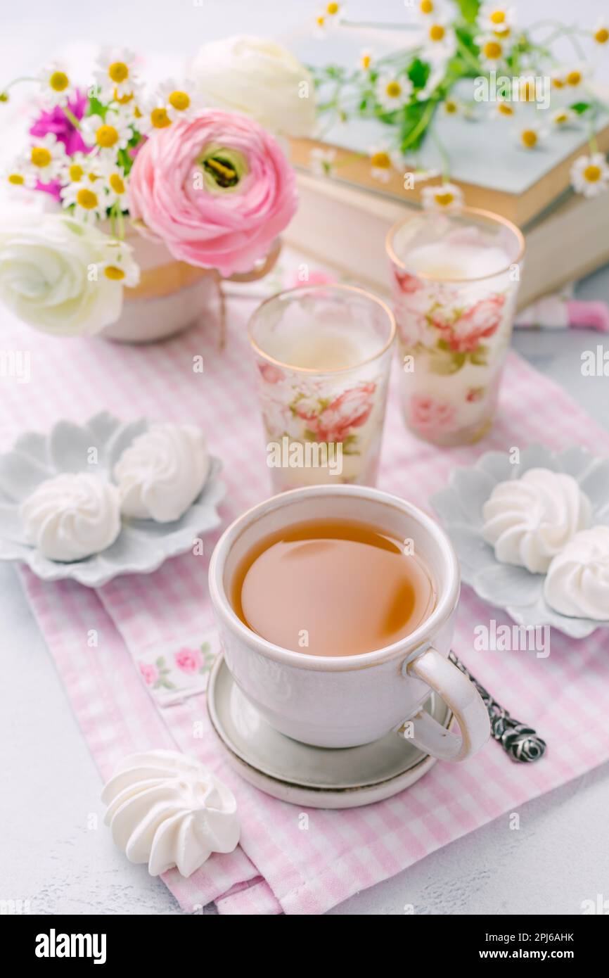 Cup of tea, small meringue cookies and books with beautiful tender ...