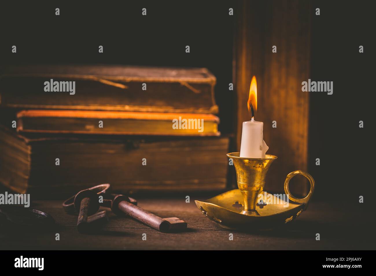 Pile of old antique books with candle and old rusty keys in vintage ...