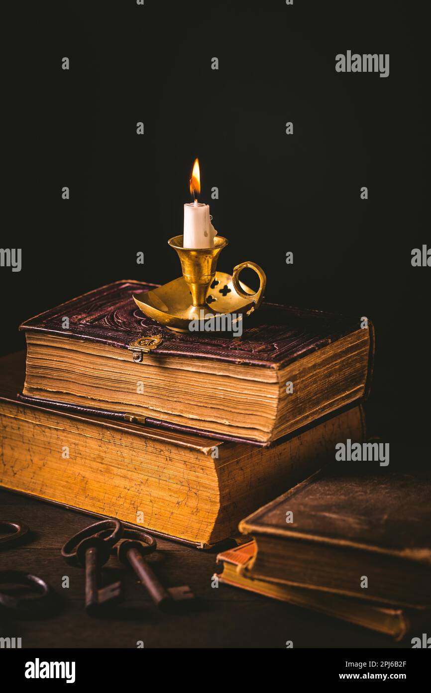 Pile of old antique books with candle and old rusty keys in vintage ...