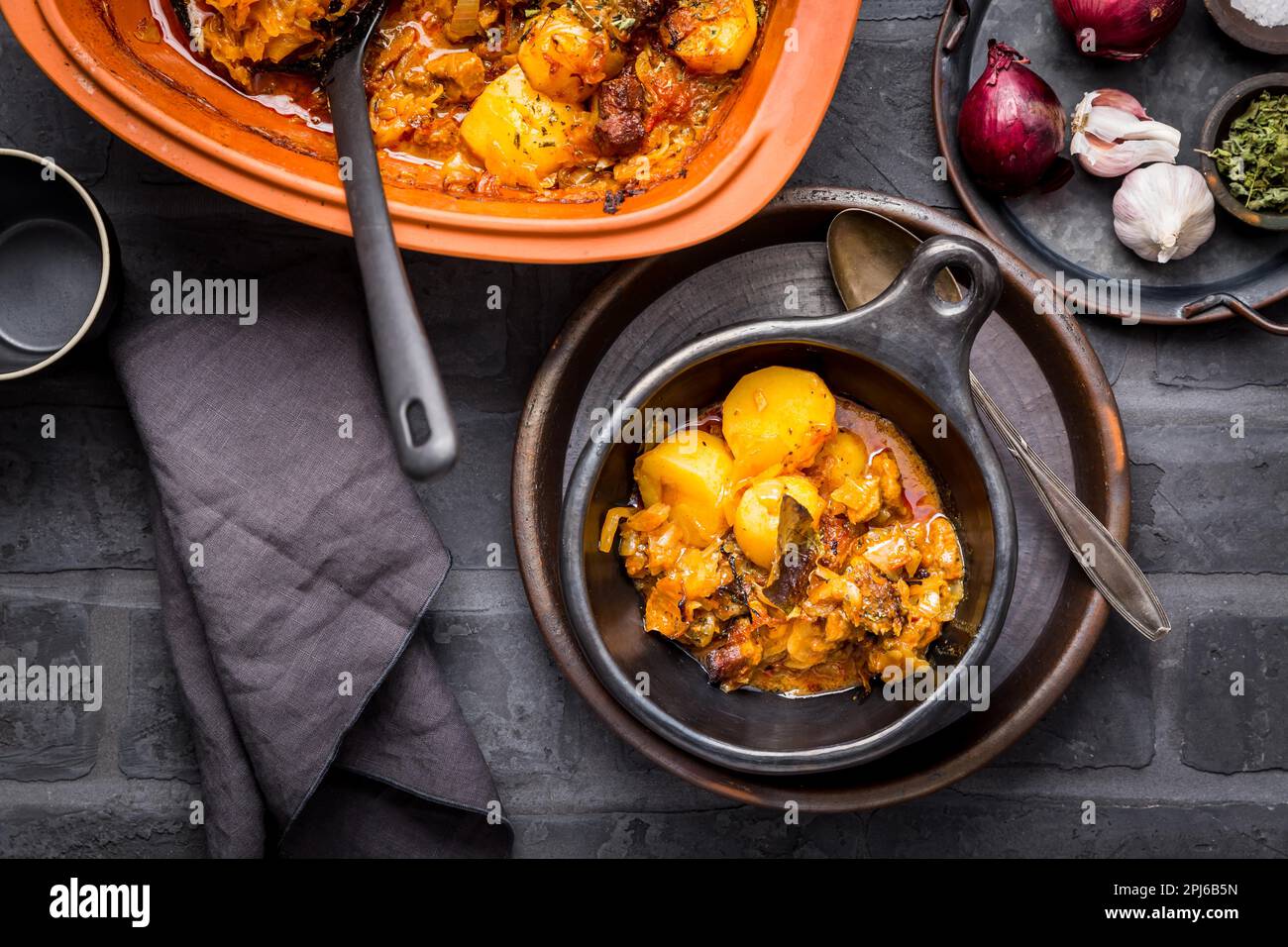 Homemade goulash with potatoes and sauerkraut. Beef and vegetable stew cooked in clay pot Stock ...
