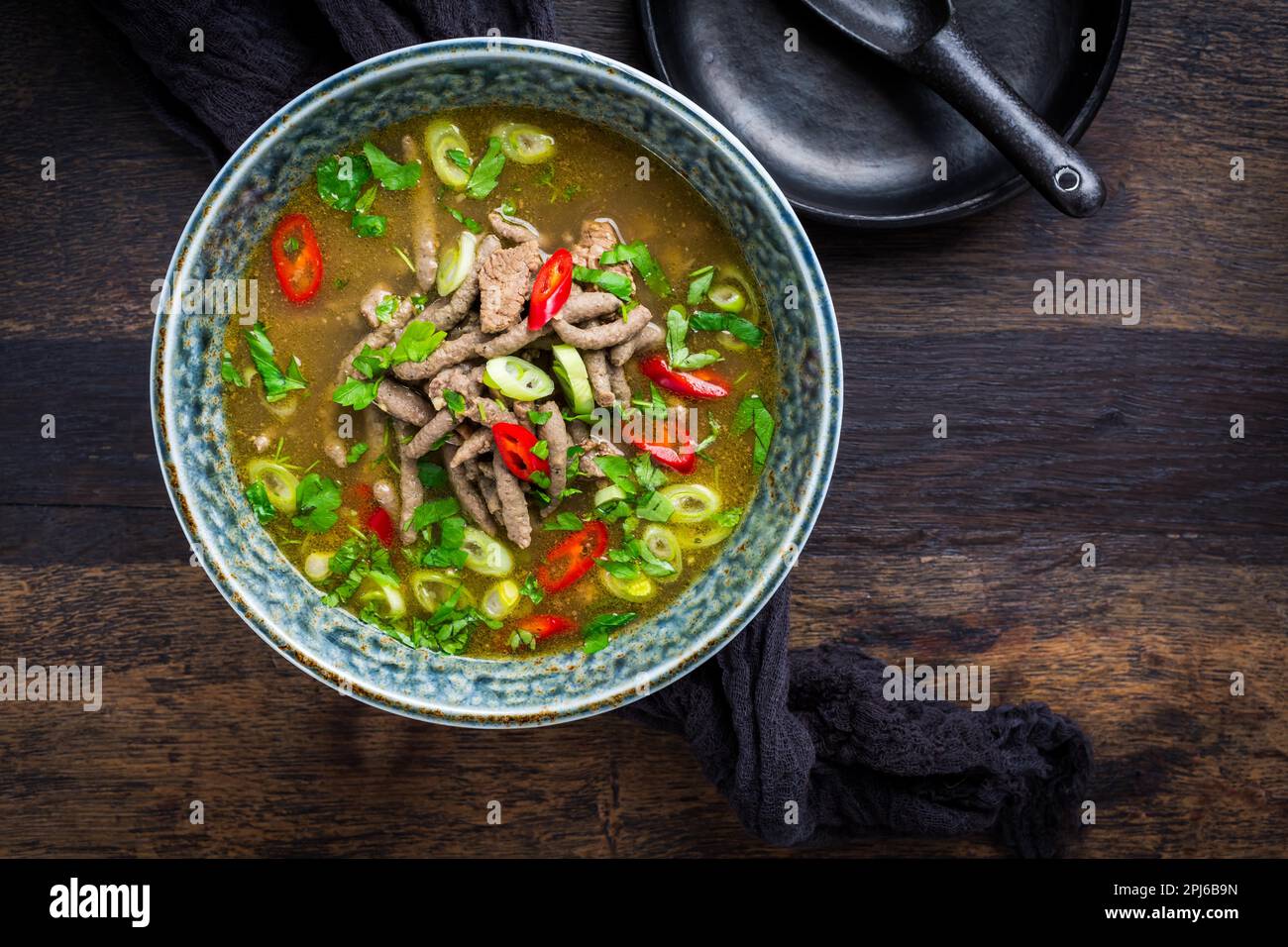 German liver dumpling soup with onion and vegetable on dark background ...