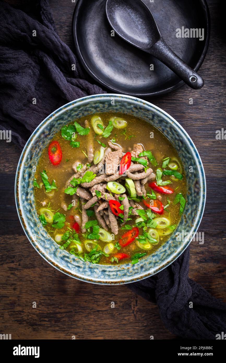 German liver dumpling soup with onion and vegetable on dark background ...