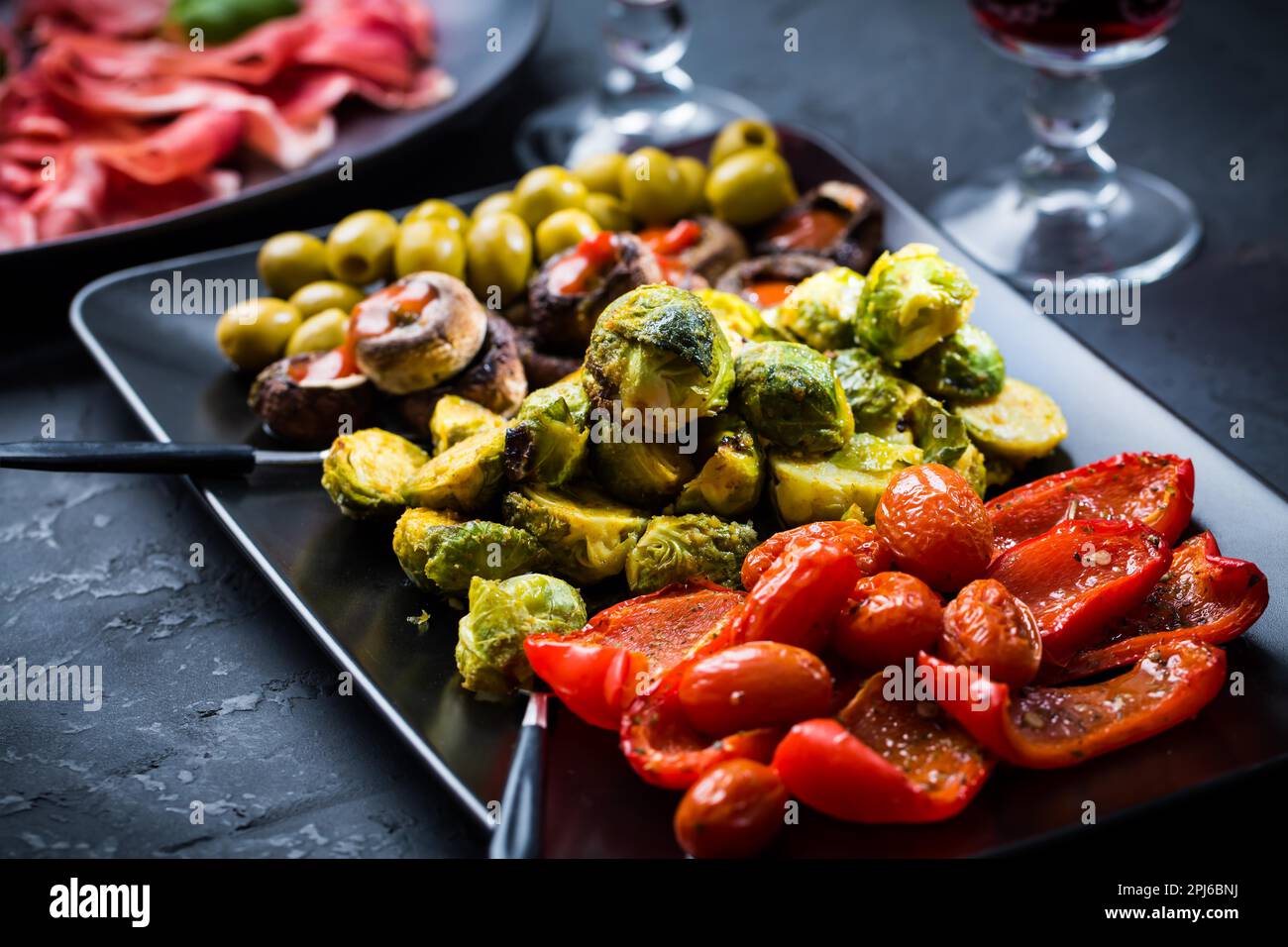 Assortment of appetizers and tapas with red wine on black background ...