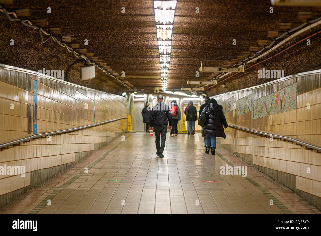 A group of people walking down an underground subway station, New York ...