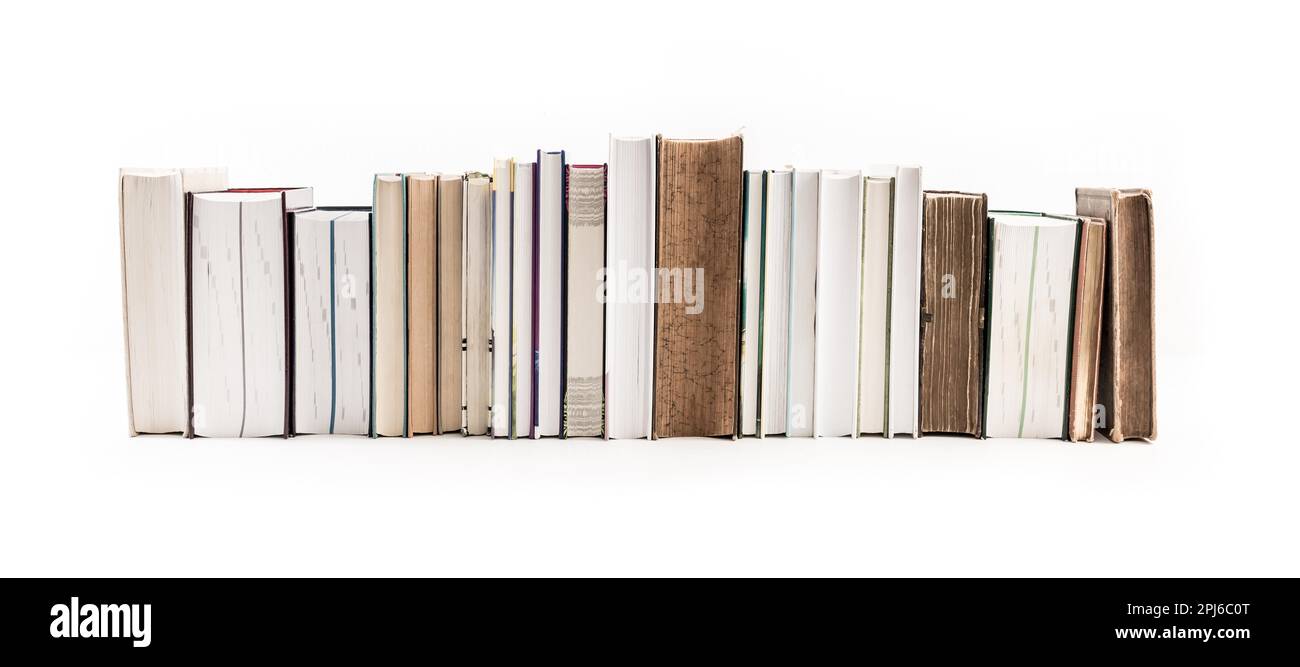 Assortment of new and old books in a row isolated on white background ...