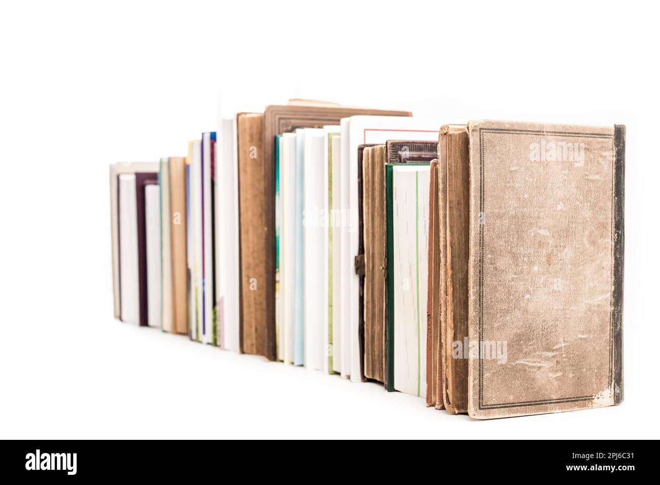 Assortment of new and old books in a row isolated on white background ...