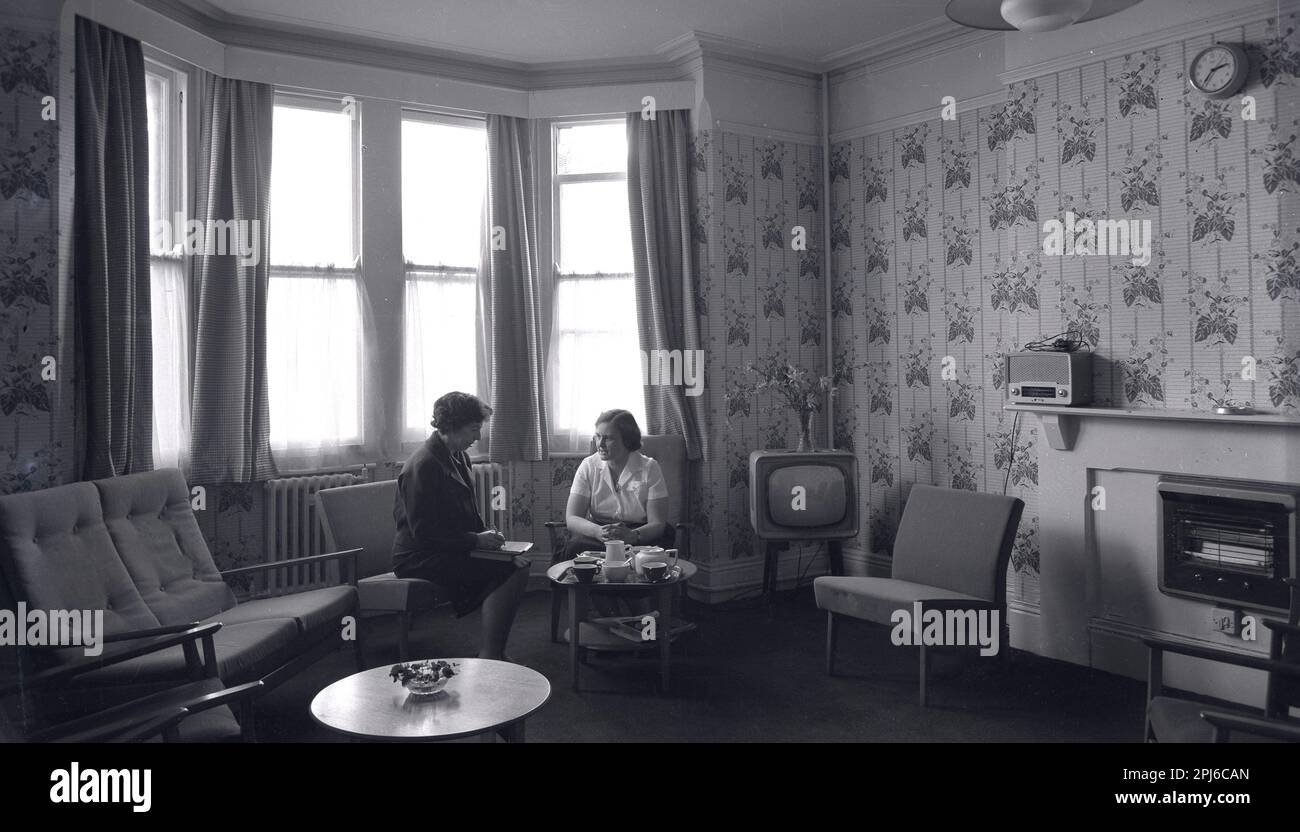 1950s, historical, lady house manager sitting with a female member of ...
