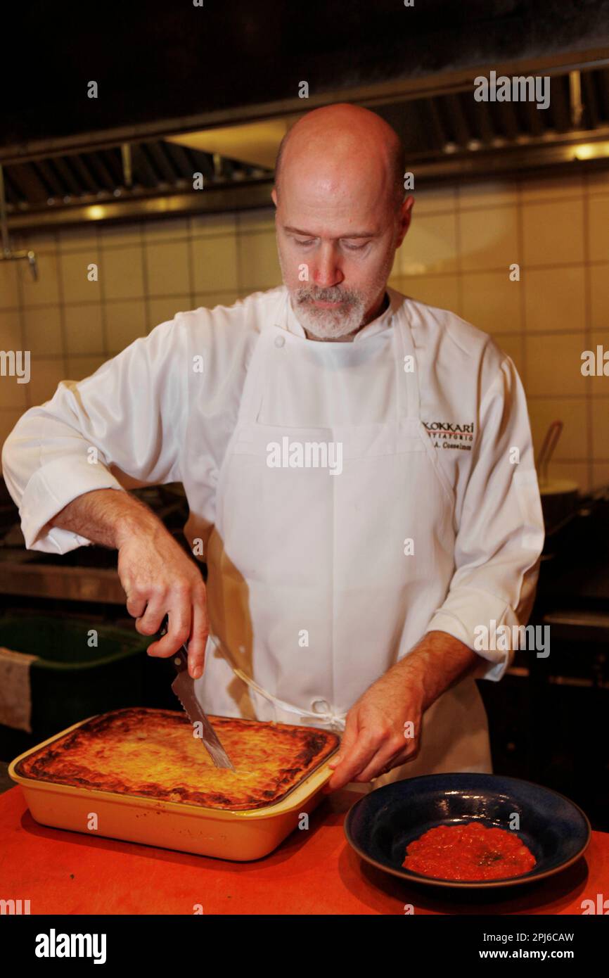 Kokkari executive chef Erik Cosselmon slices a serving out of a pan of ...
